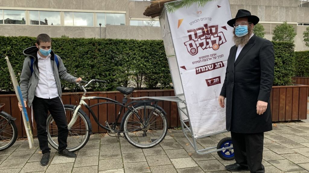 Rabbijn met loofhut achter fiets door Den Haag voor religieus feest