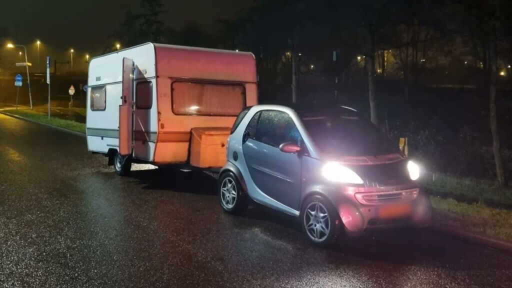 Kleine Smart met fors grotere caravan tuft met 60 km/u over snelweg