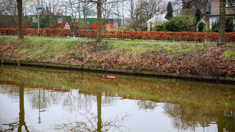 Auto rijdt water in, omstanders springen erachteraan